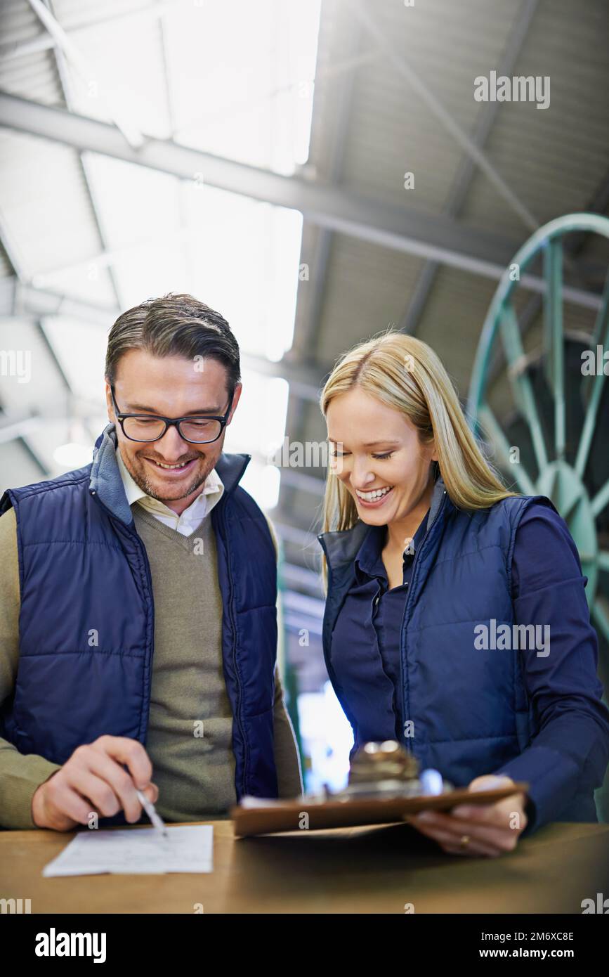 Staying organized in the warehouse. a two managers reading paperwork ...