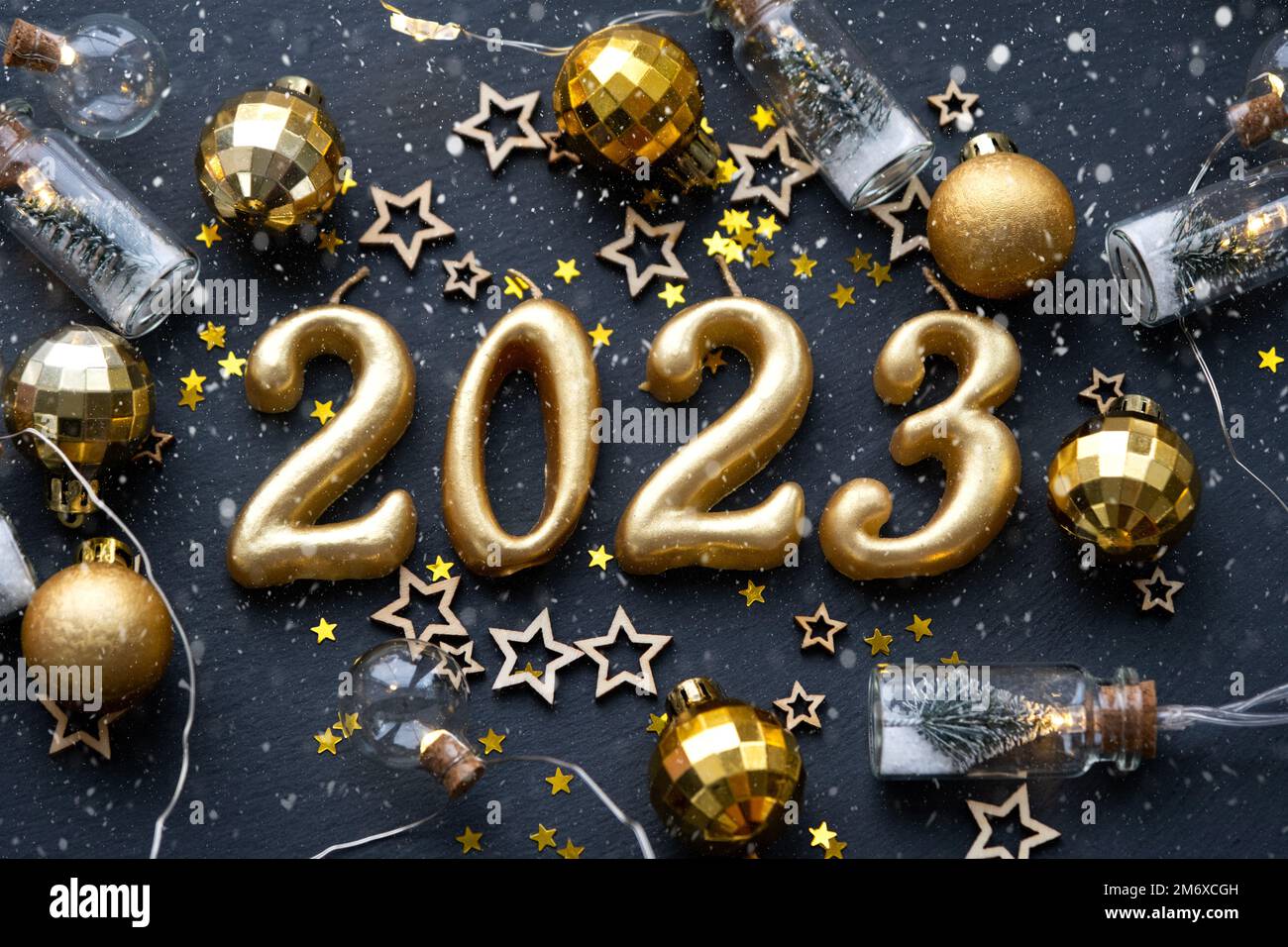 The golden figures 2023 made of candles on a black stone slate ...