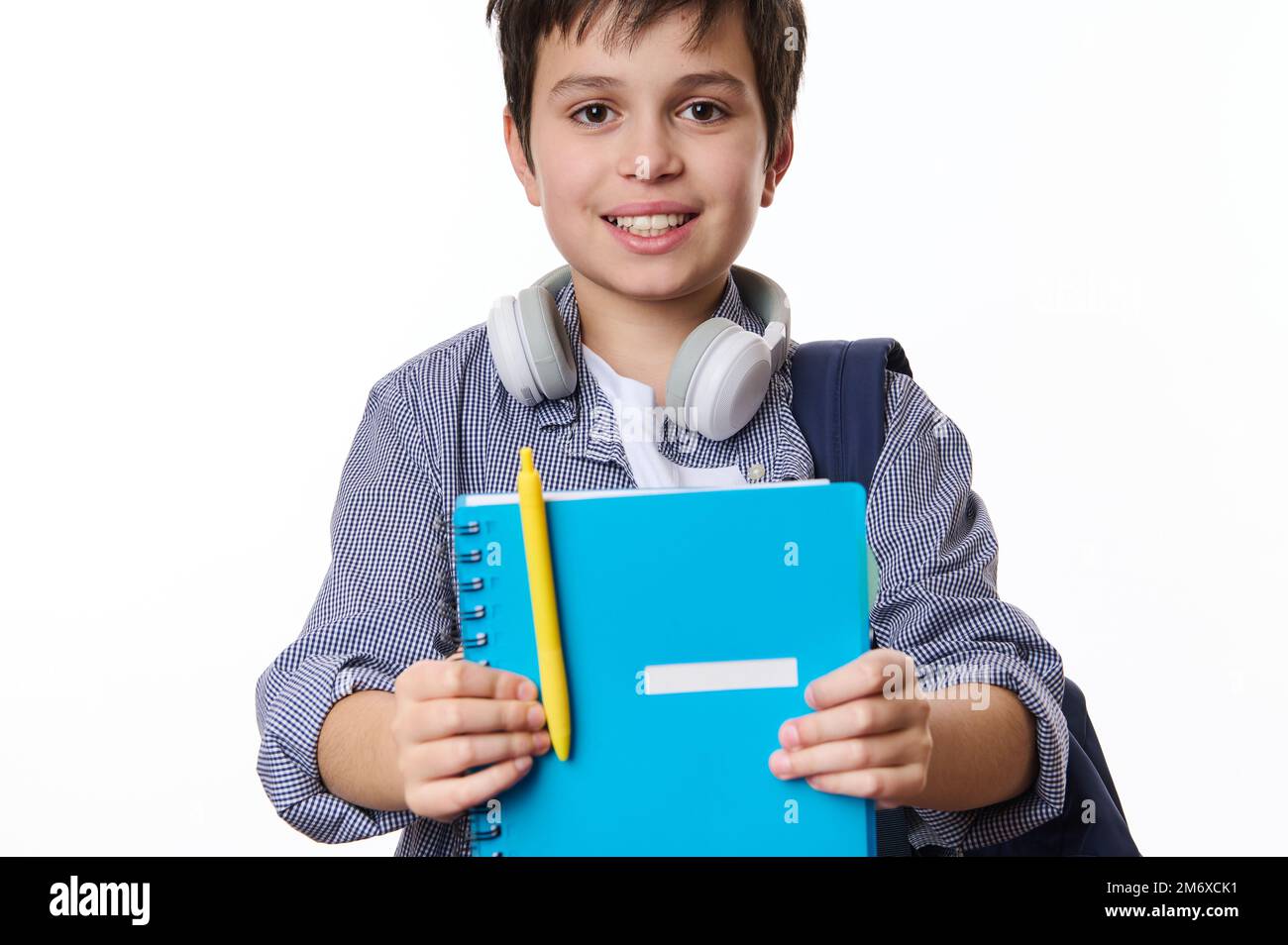Smart boy, primary school student holding out blue copybook and yellow ...