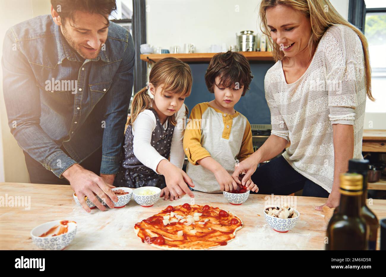 The kitchen is the heart of the home. a family enjoying pizza at home ...