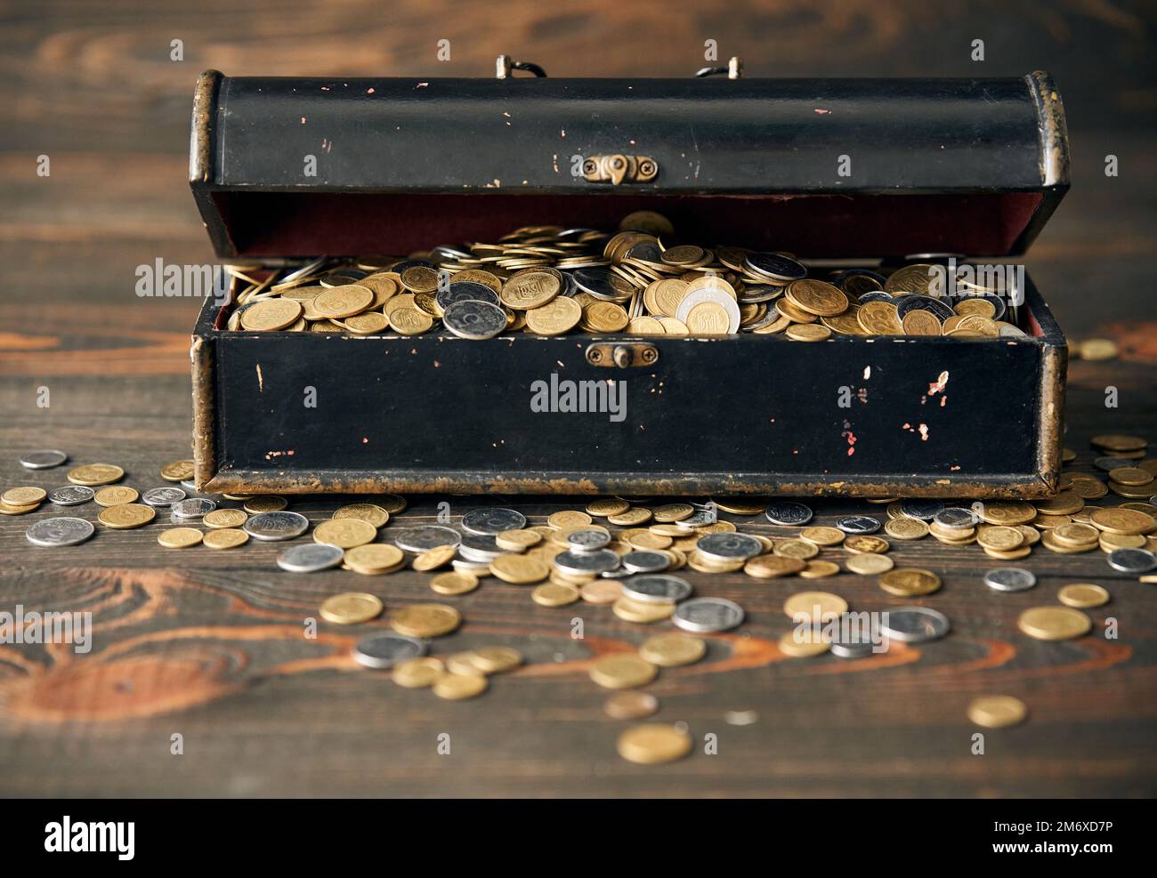 Old chest full of coin on wooden background Stock Photo - Alamy