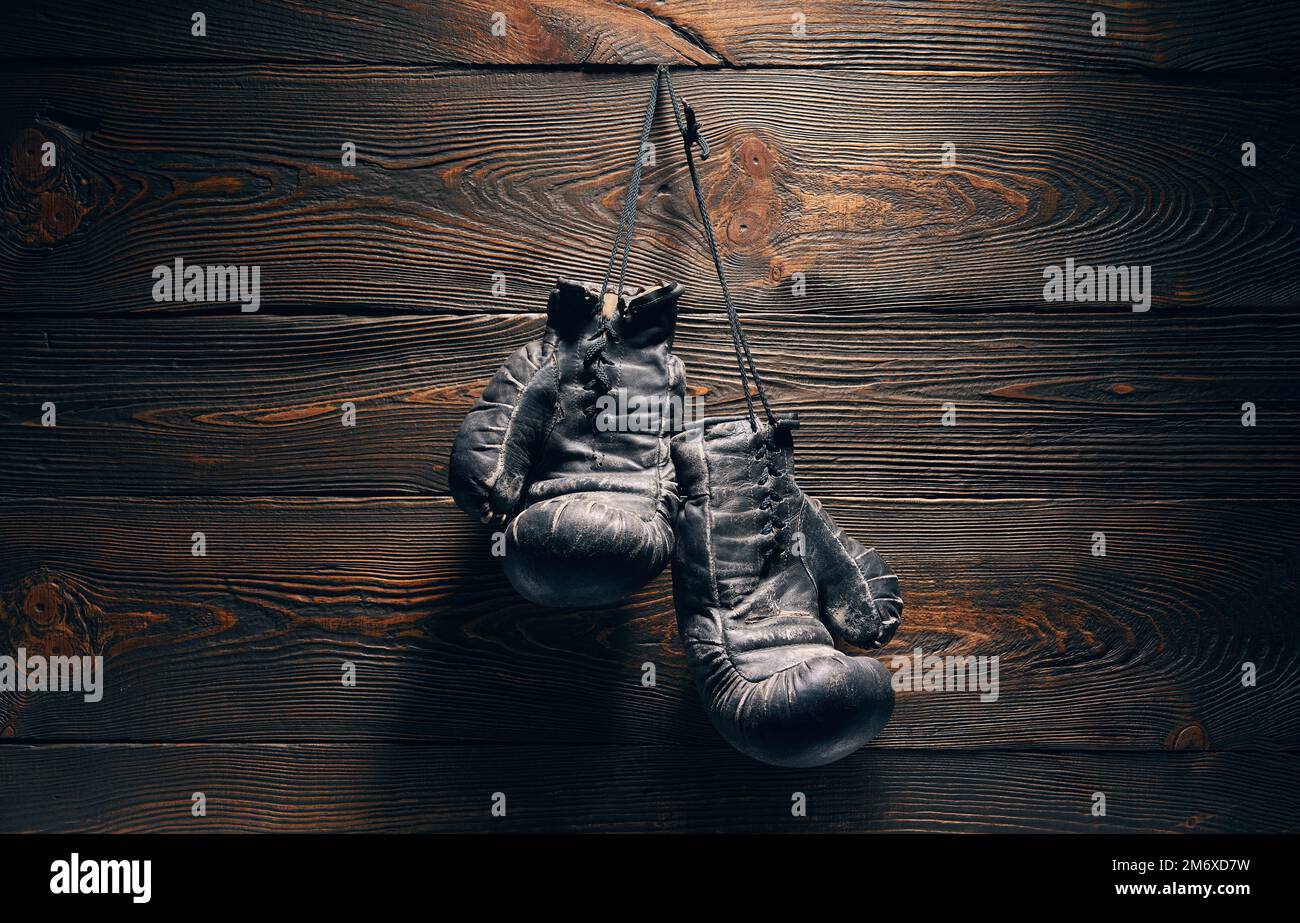 Old boxing gloves hanging on nail on wooden wall Stock Photo - Alamy
