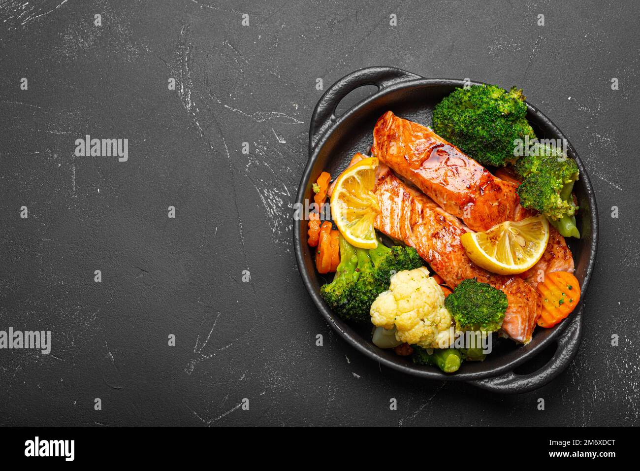 Healthy baked fish salmon steaks, broccoli, cauliflower, carrot in cast ...