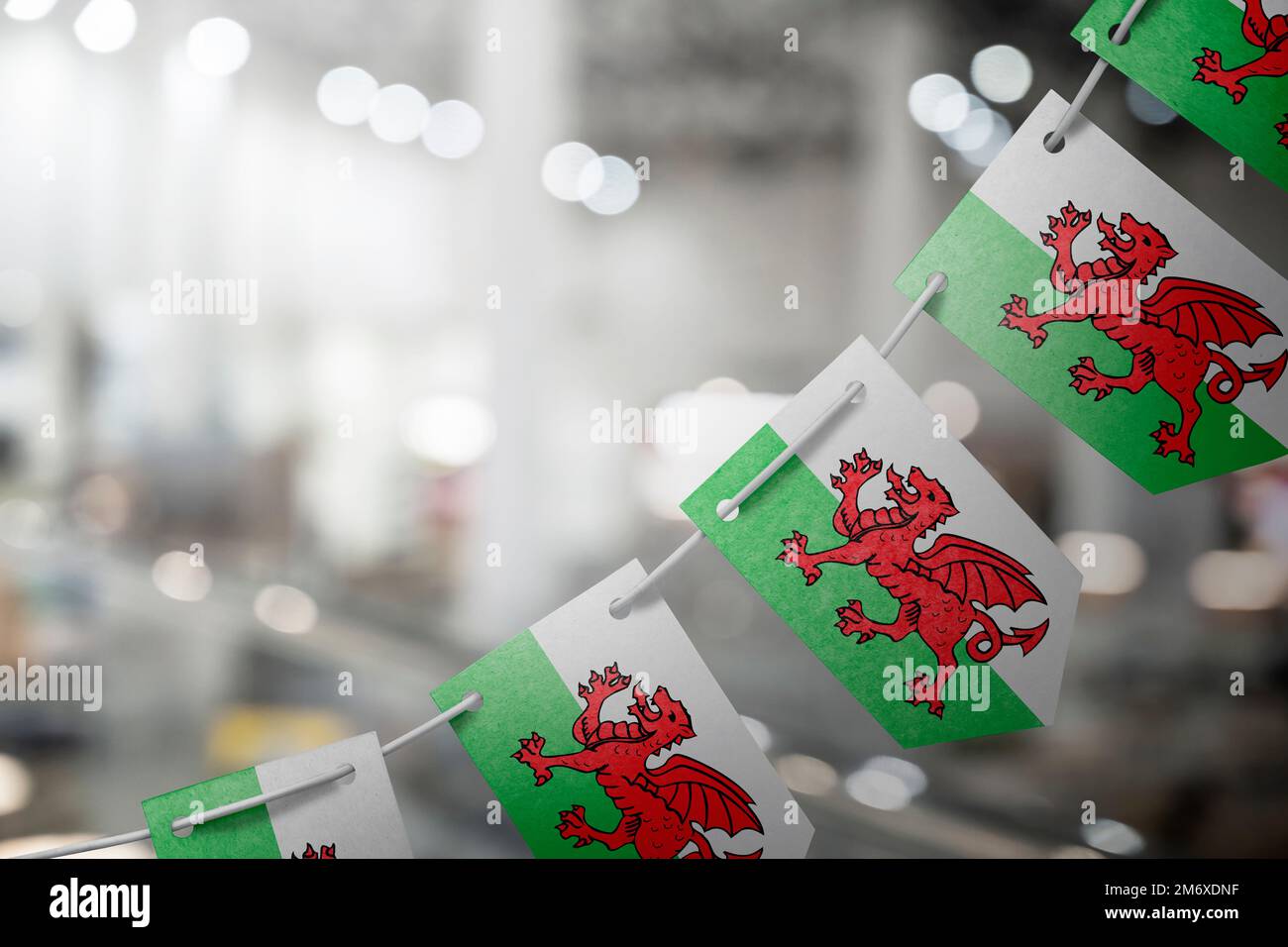 A garland of Wales national flags on an abstract blurred background ...