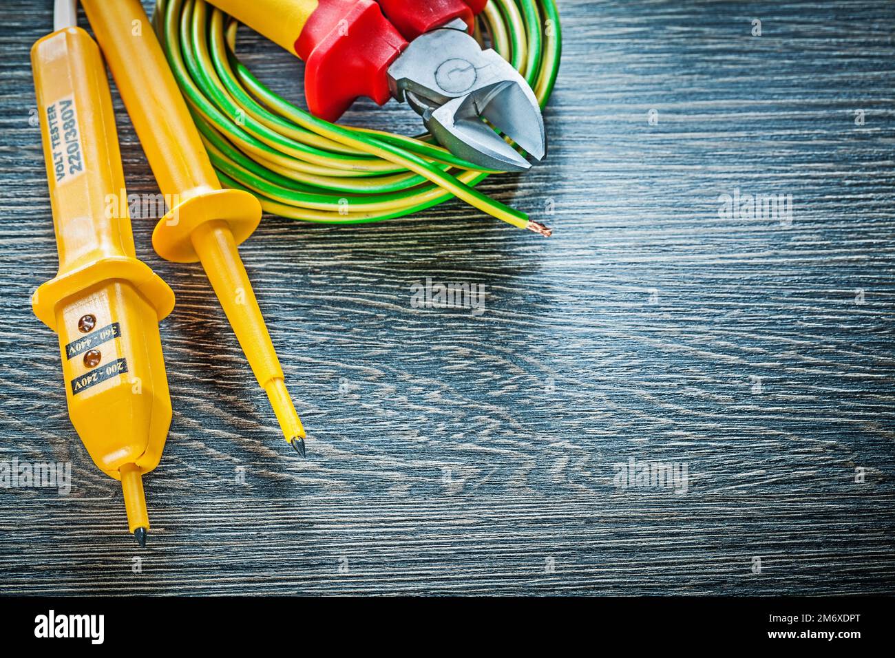 Electrical tester cutting pliers rolled wire on wood board Stock Photo ...
