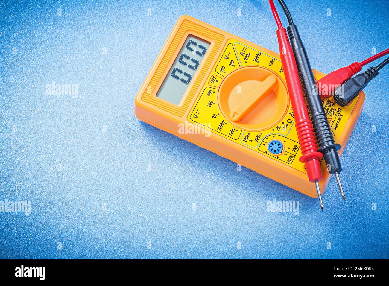 Electrical digital multimeter on blue background directly above ...