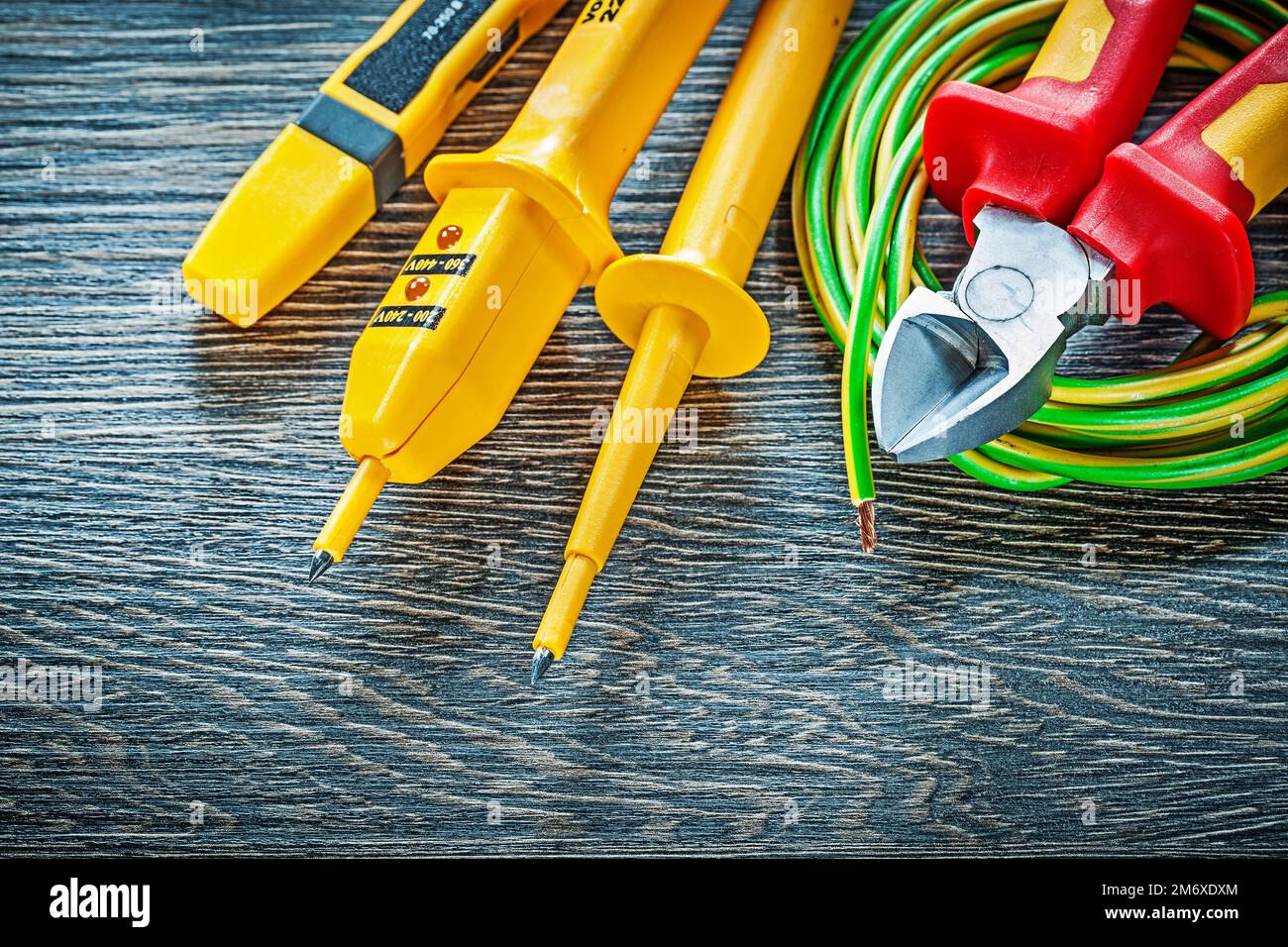 Electrical tester nippers rolled wire on wood board Stock Photo - Alamy