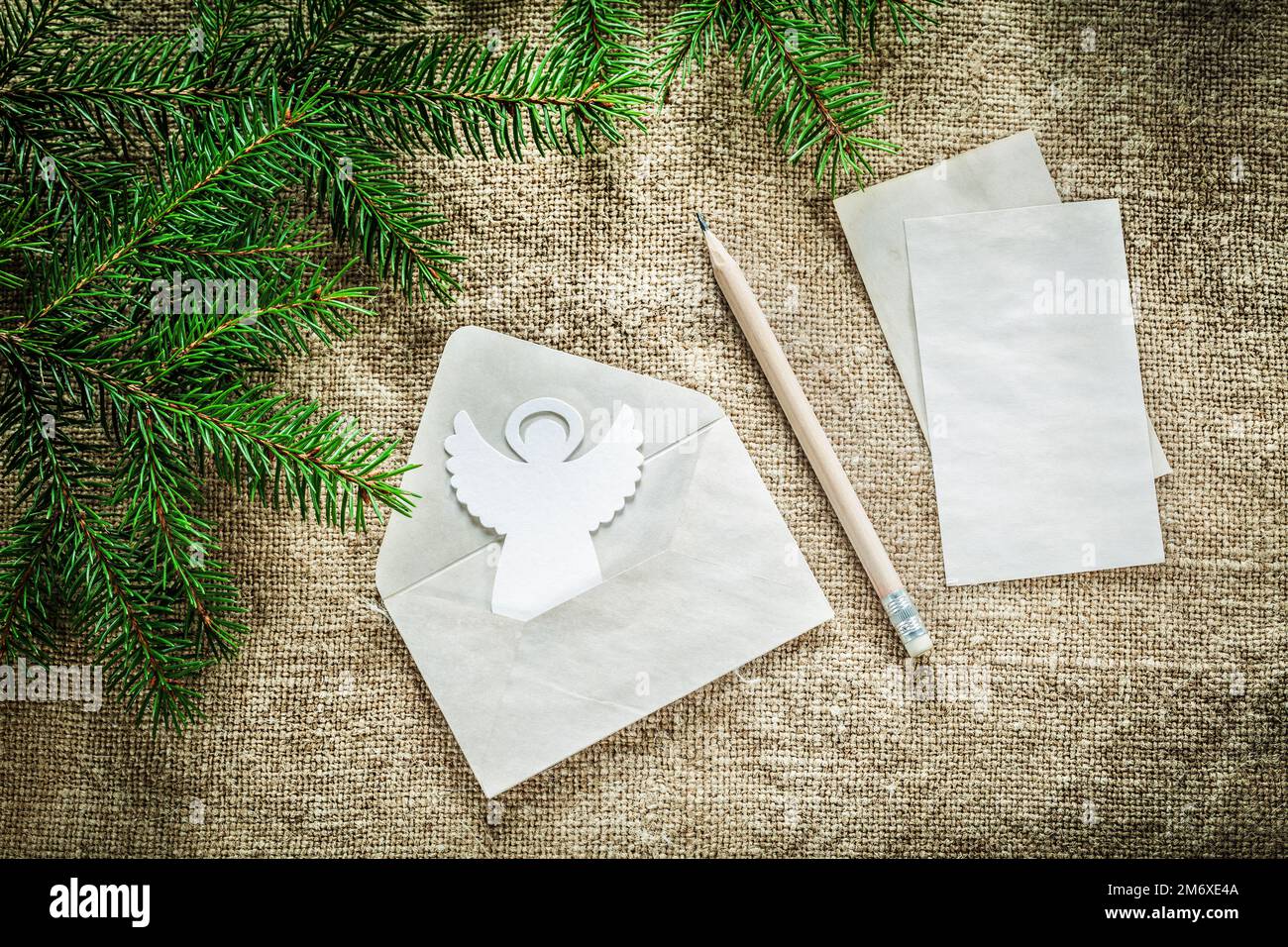 Fir tree twig envelope letter pencil angel on sacking background Stock ...