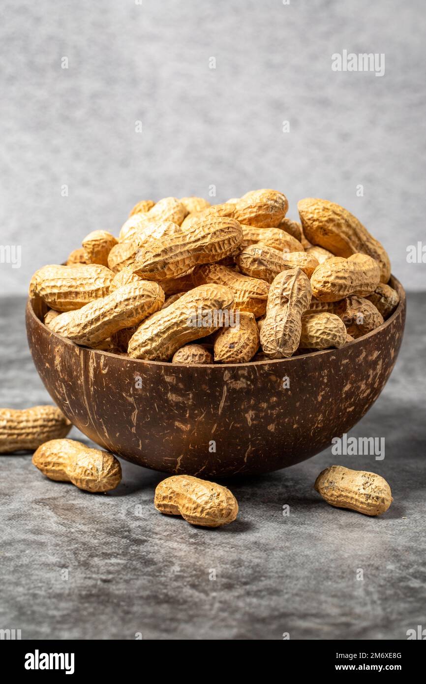 Peanuts in shell on dark background. Peanuts in a coconut bowl. close ...
