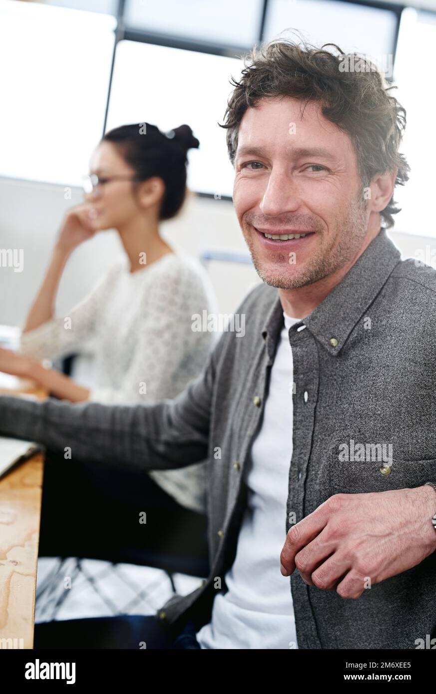 Make creativity a job. Portrait of two smiling office workers sitting ...
