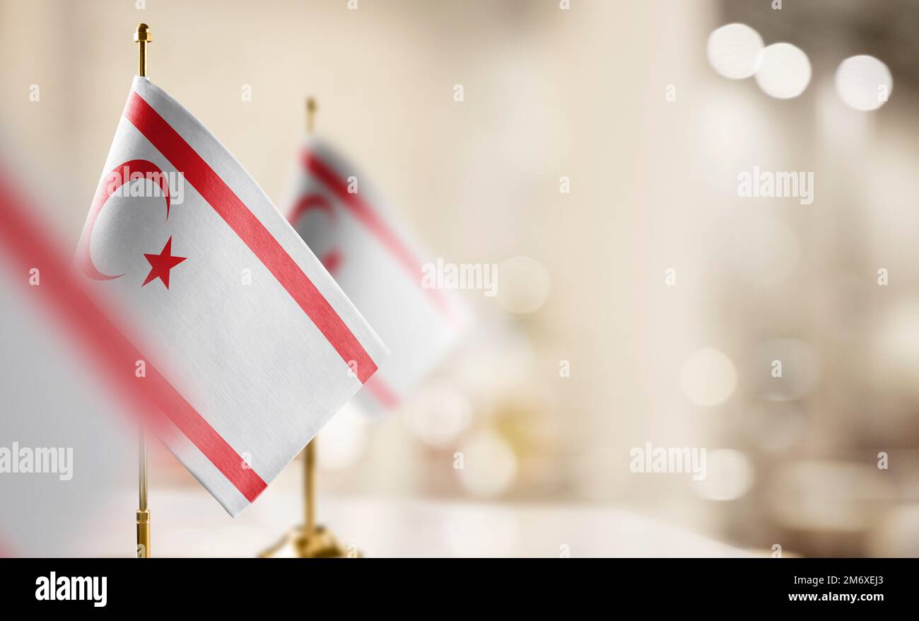 Small flags of the Northern Cyprus on an abstract blurry background ...