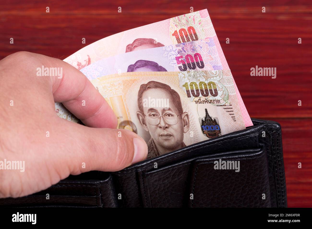 Thai money - baht in the black wallet Stock Photo - Alamy