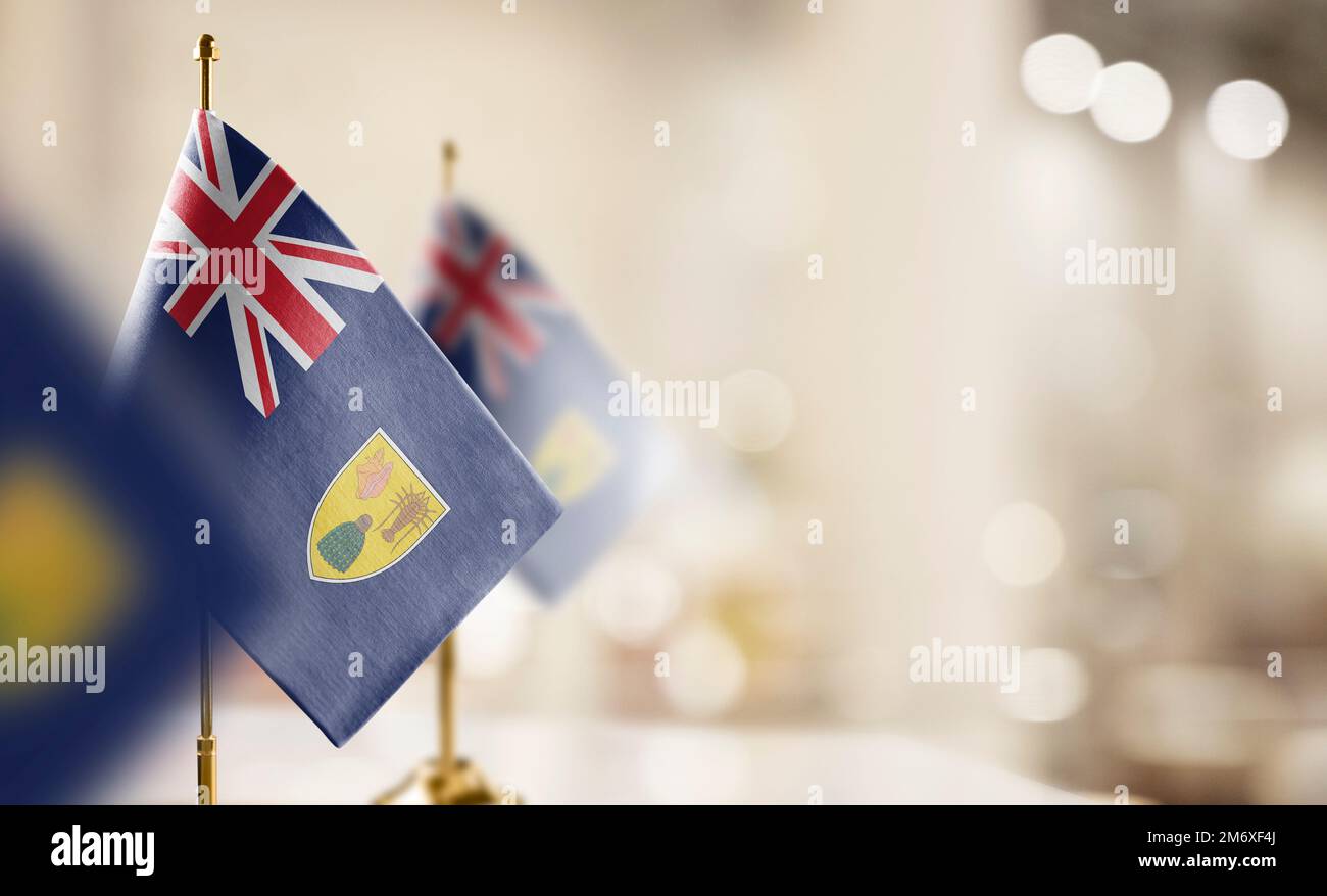 Small flags of the Turks and Caicos Islands on an abstract blurry ...