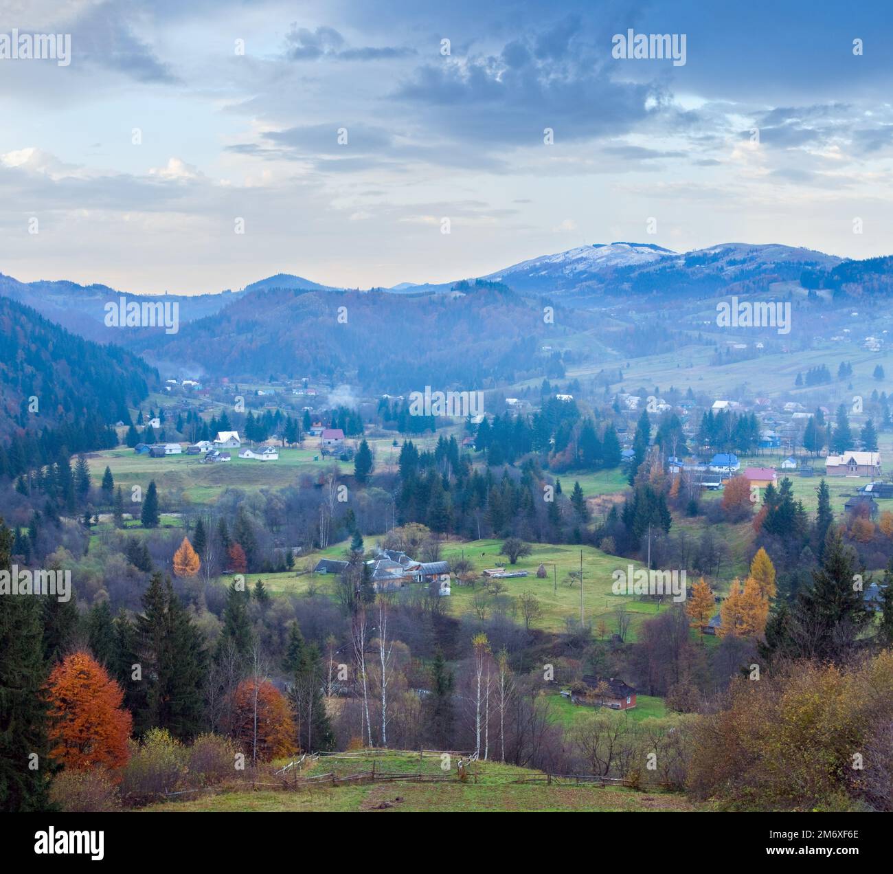 Autumn misty mountain landscape (dull day) with village in valley ...