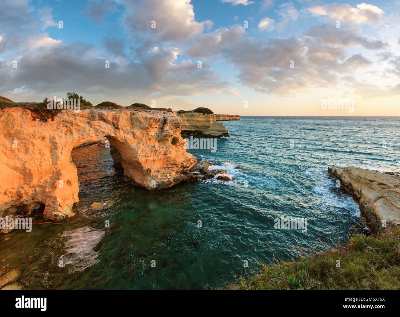 Sunrise seascape with cliffs, rocky arch and stacks (faraglioni), at ...