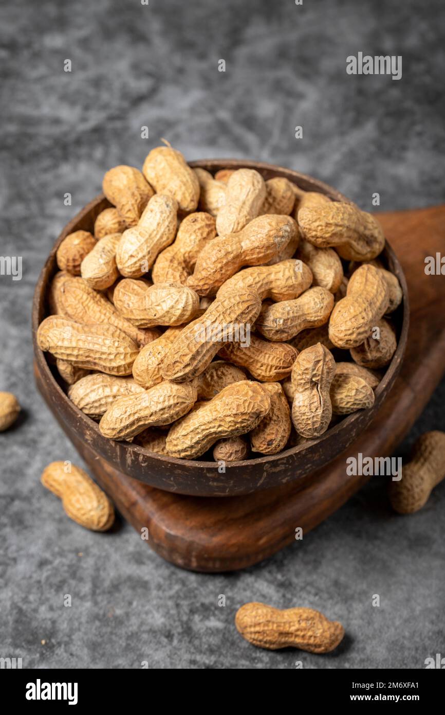 Peanuts in shell on dark background. Peanuts in a coconut bowl. close ...