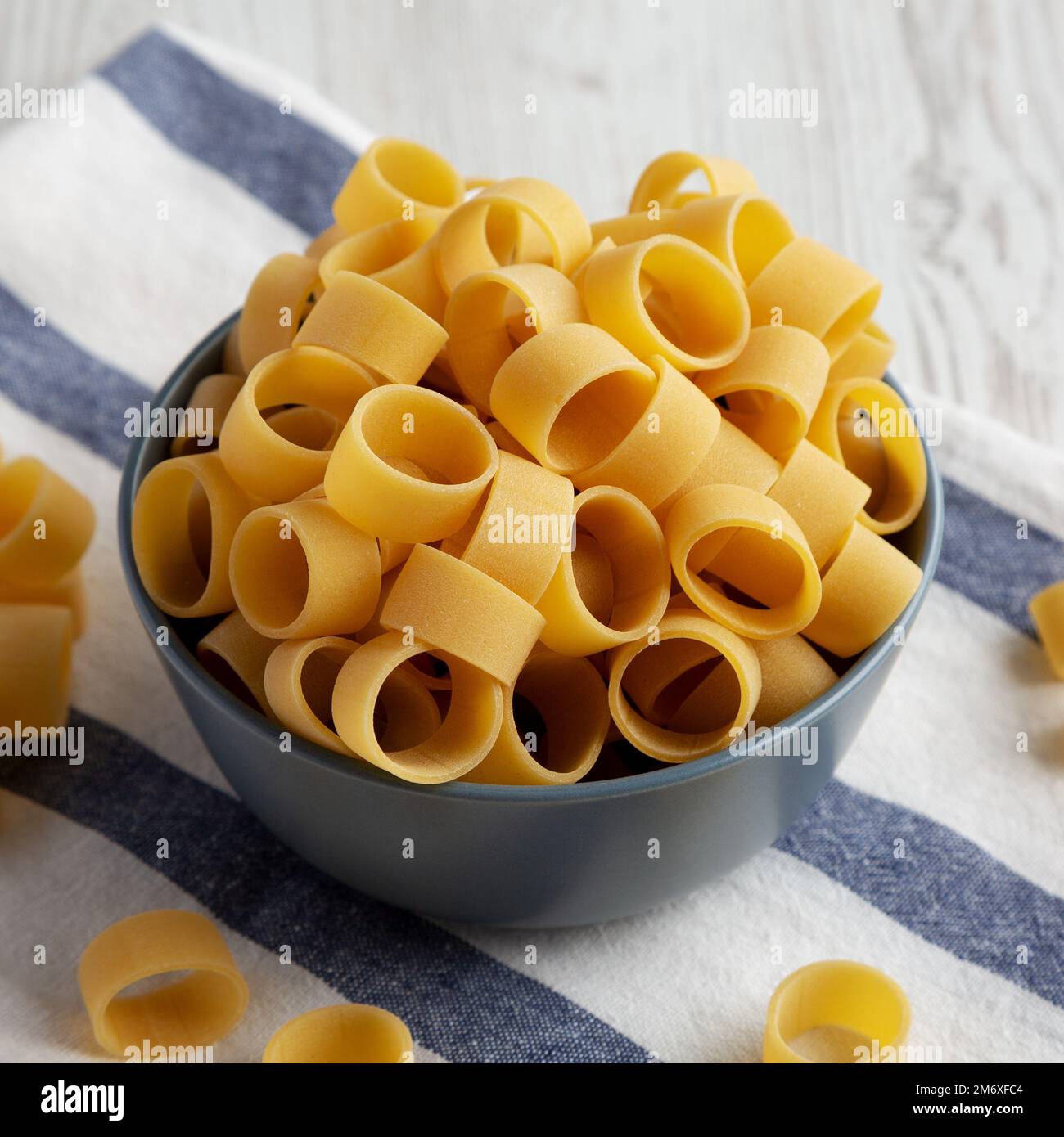 Raw Uncooked Pasta Calamarata in a Bowl, side view Stock Photo - Alamy