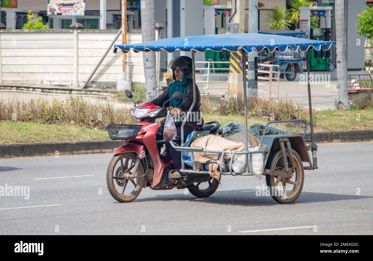 RATCHABURI, THAILAND, NOV 16 2022, A woman rides a motorcycle with a full loaded sidecar Stock ...