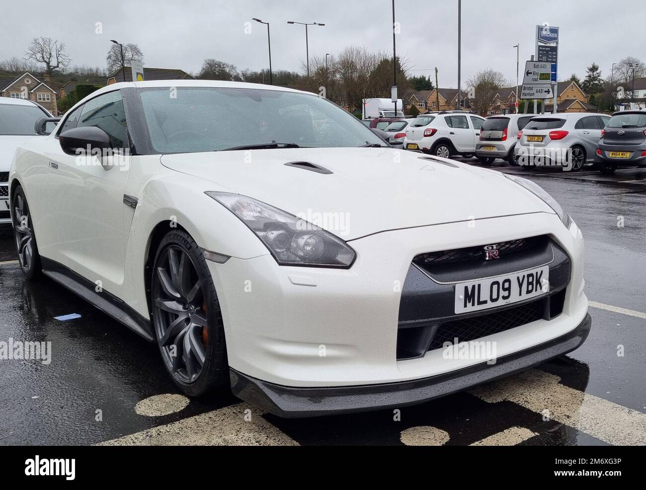 A front view of a white Nissan GTR Nismo in a parking lot on a rainy ...