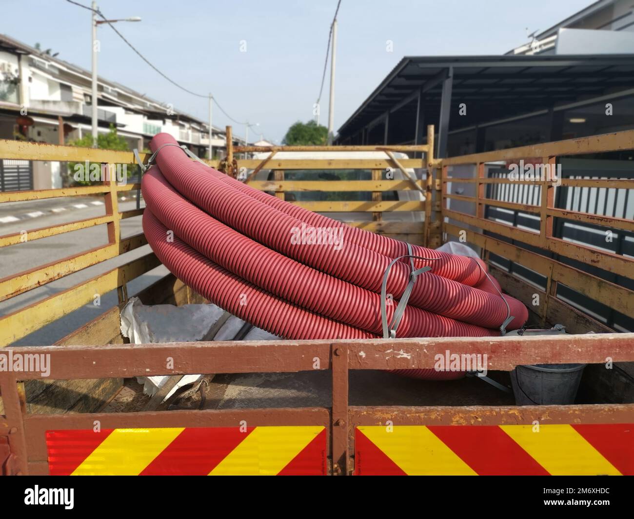bundle of vermilion red PVC plastic industrial pipe hose at the back of ...