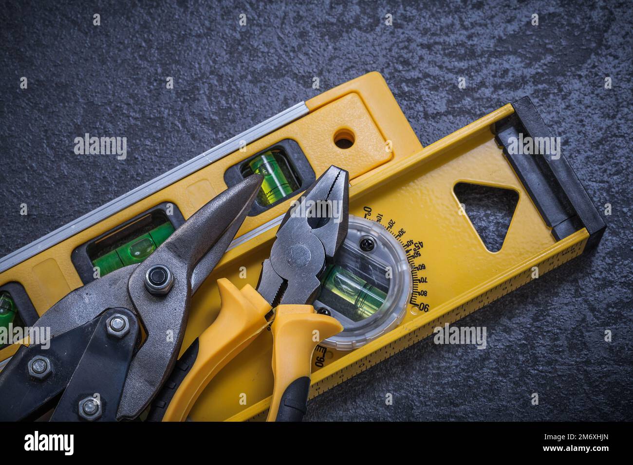 Composition of steel cutter pliers construction level on black ...