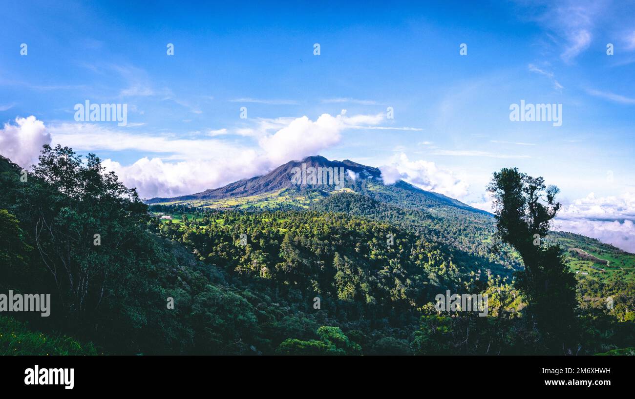 A scene of the Turrialba Volcano with clouds surrounded by green ...