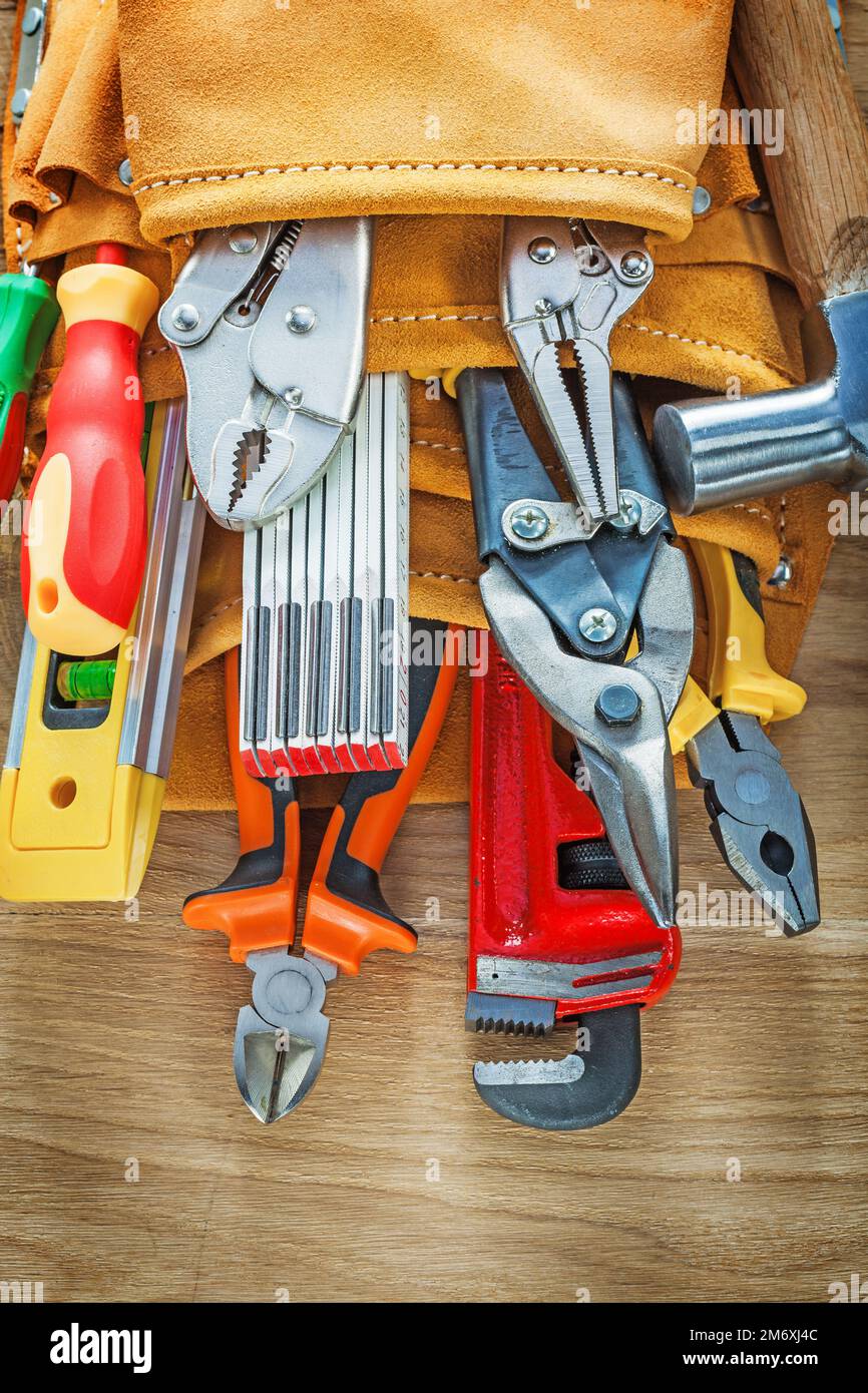 Construction tools in leather building belt on wood board Stock Photo ...