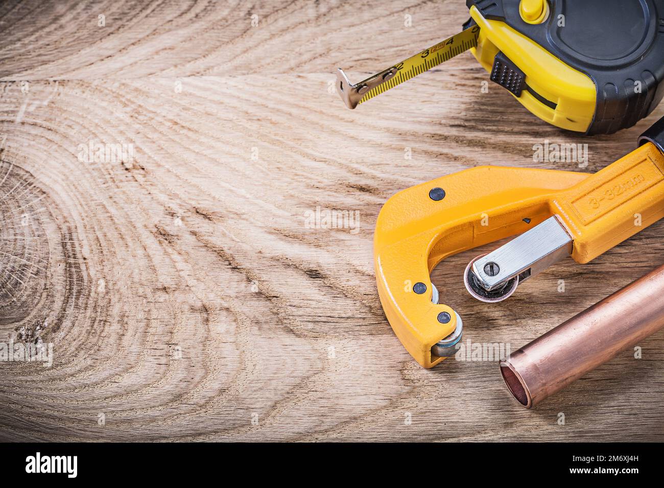Copper water pipe cutter measuring tape on wooden board plumbing ...
