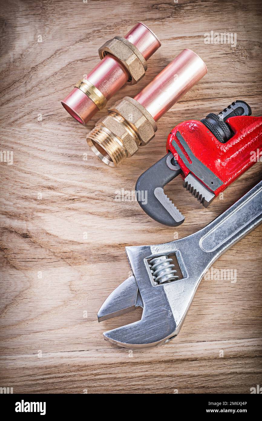 Copper water pipe hose nipples monkey wrench adjustable key on wooden ...