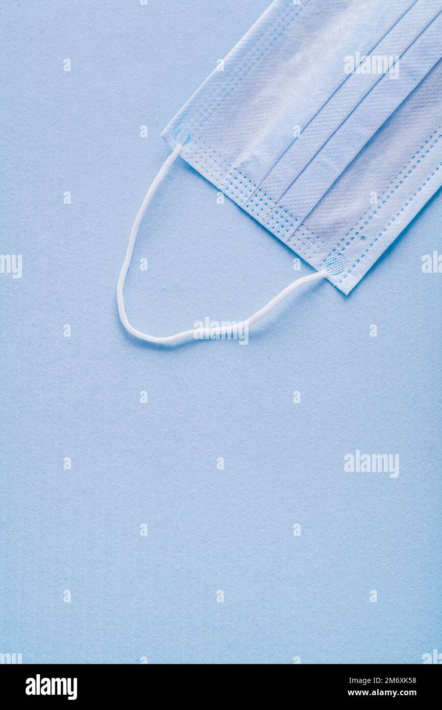 disposable face mask on blue background with copyspace vertical version ...