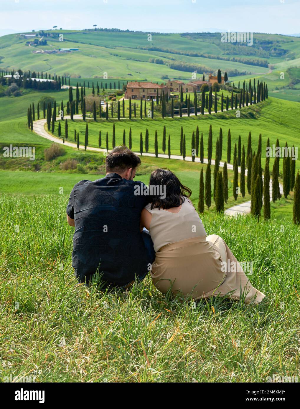 Young couple with the traditional Tuscan farm with cypress trees alley ...