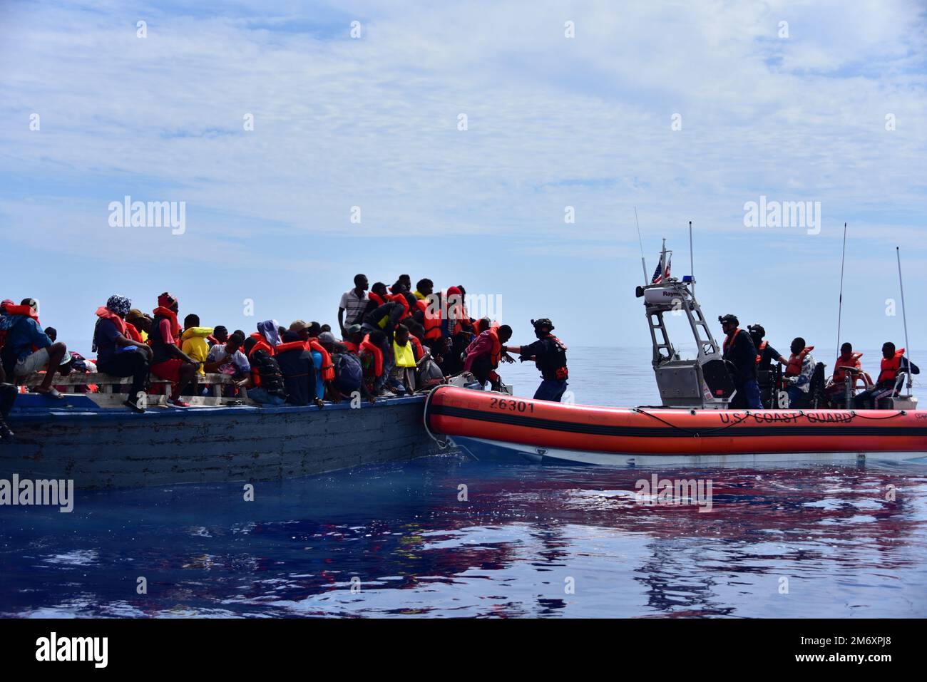 Haitians are transferred from a grossly overloaded, unsafe vessel to ...