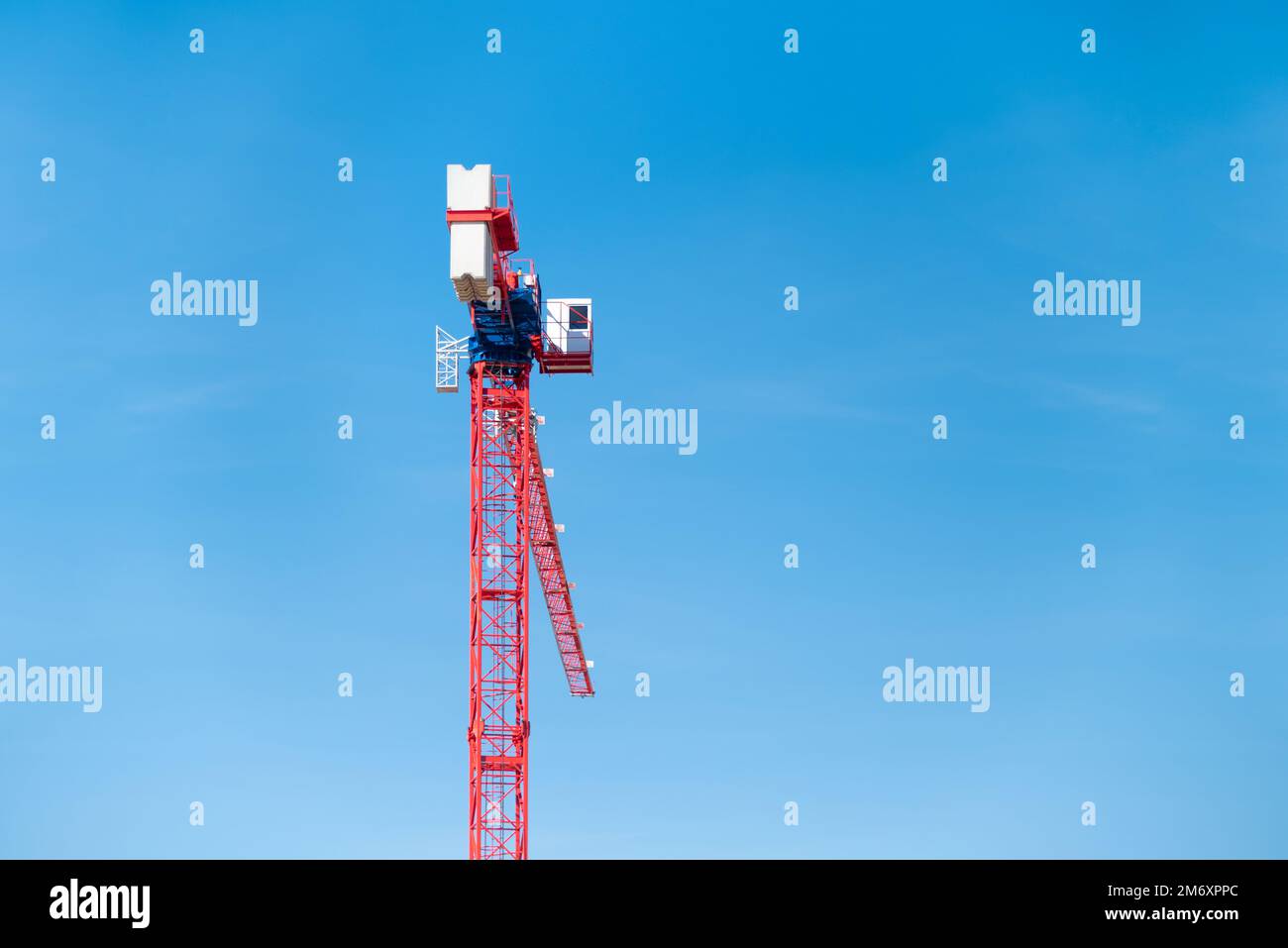 Back view of big red construction crane in front of cloudless sunny ...