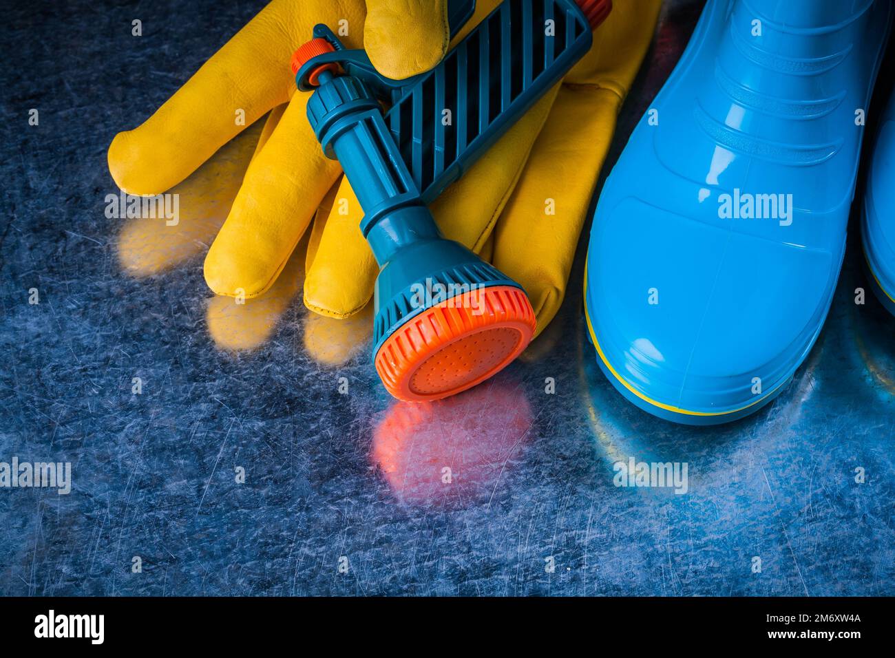 Composition of rubber boots leather safety gloves and water sprayer ...