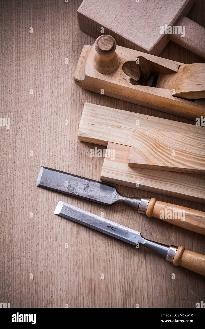 Hand mallet shaving plane metal chisels and wooden stud on brown board ...