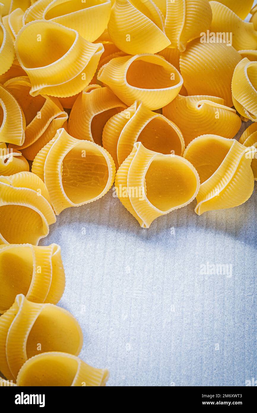 Heap of raw shell macaroni on blue background food and drink concept ...