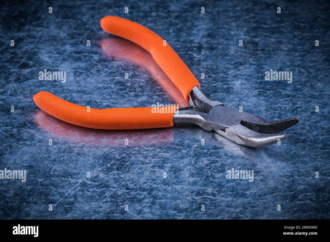 Insulated electric gripping tongs on scratched metallic background ...