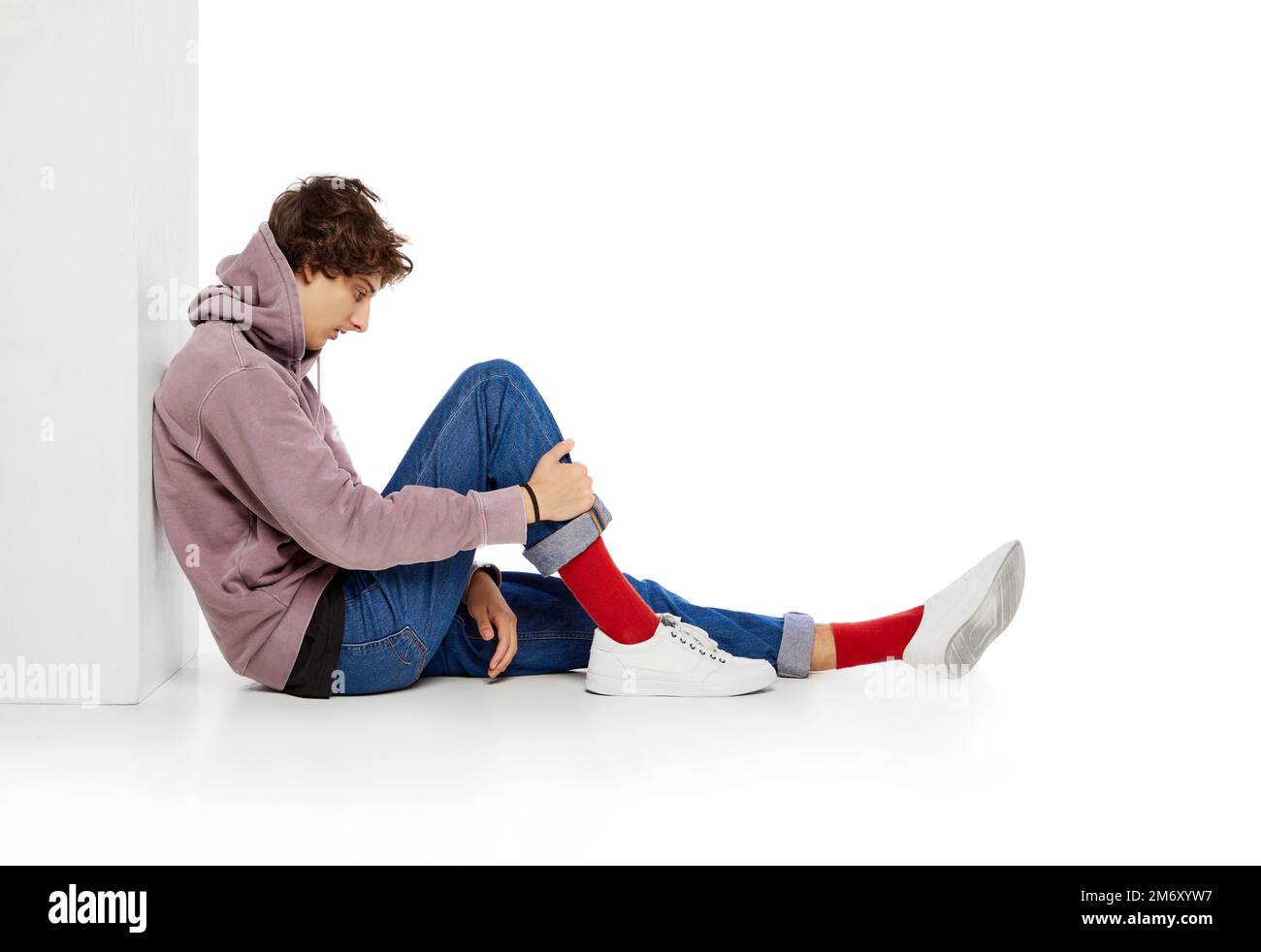 Portrait of young boy in casual clothes sitting with thoughtful face ...