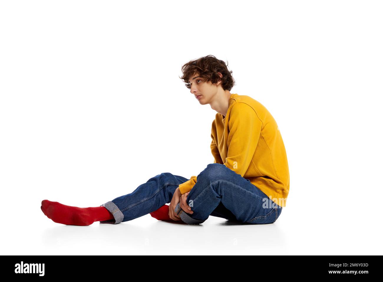 Portrait of young boy sitting on floor in sadness, feeling asocial over ...