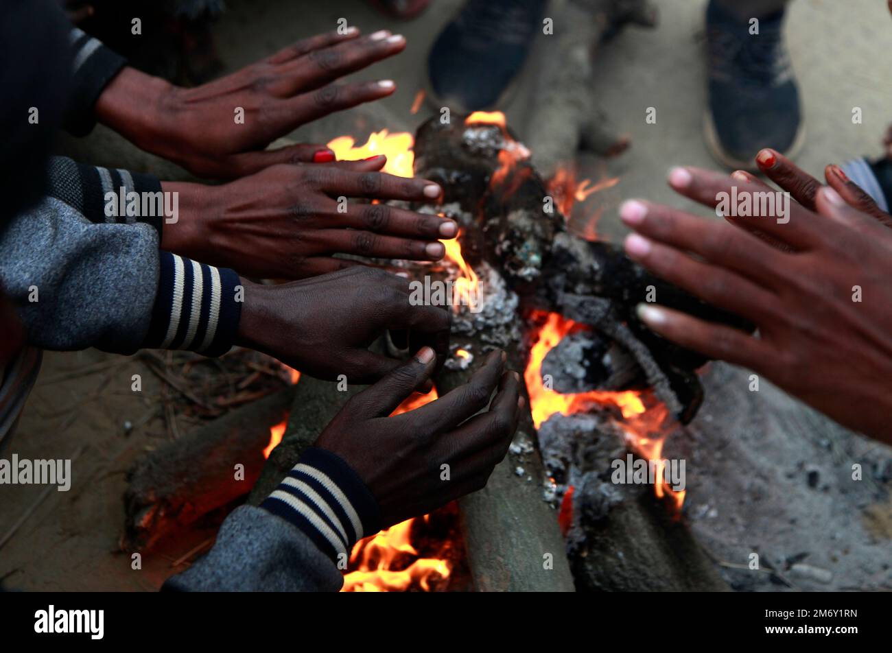Prayagraj, India. 06/01/2023, People warm themselves in a foggy and ...
