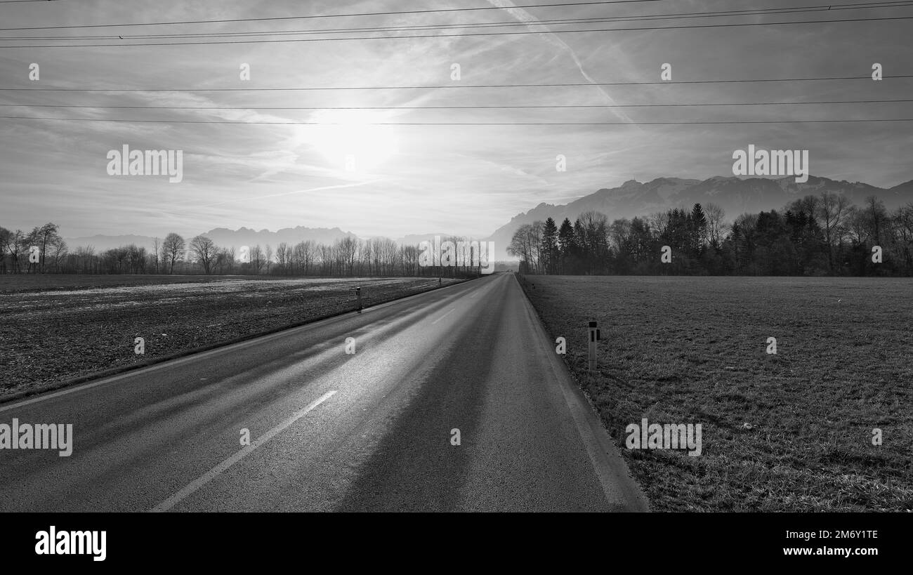 Highway in winter landscape with mountains in background and power ...