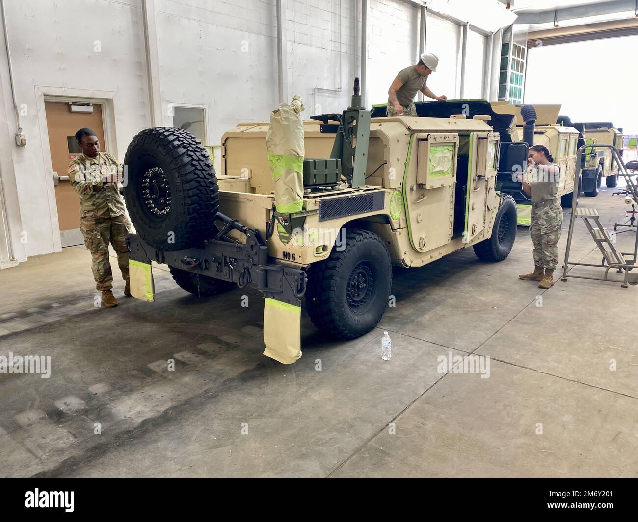 Soldiers tape over areas where paint should be avoided on three of 13th ...
