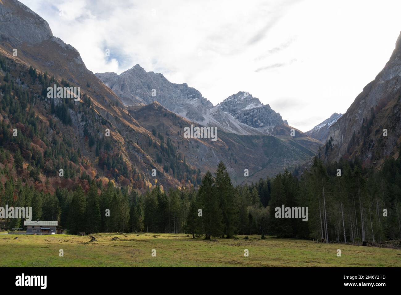 An aerial view of lush green valley surrounded by steep rocky mountains ...