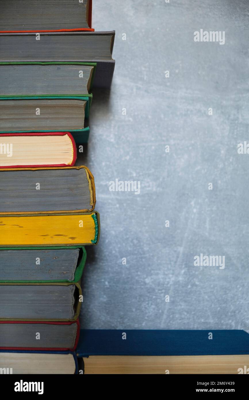 Stack of old battered books on retro photos against background concrete ...