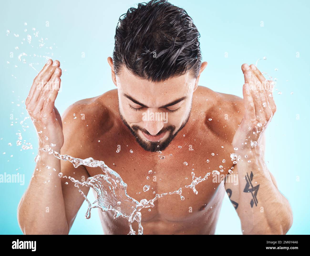 Skincare, water splash and man in a studio for a wellness, health and ...