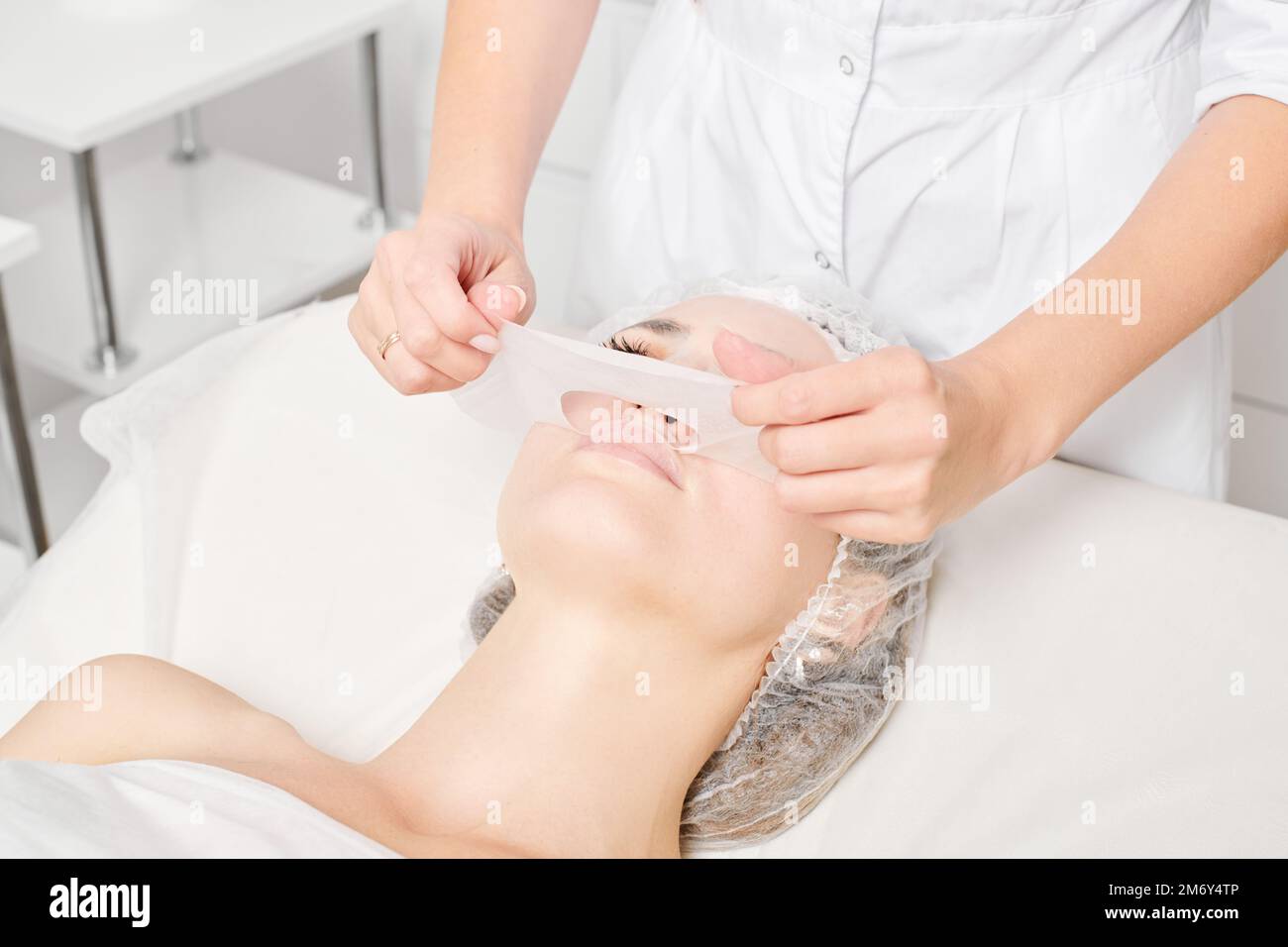 Beautician removing sheet mask on woman face for rehydrate face skin ...