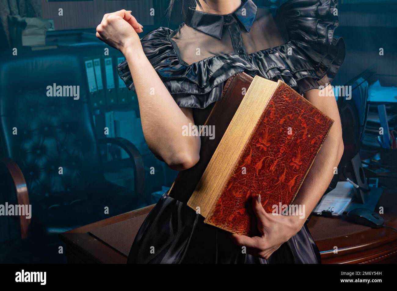 Old book in woman's hands close up. Woman holds an antique book in her ...