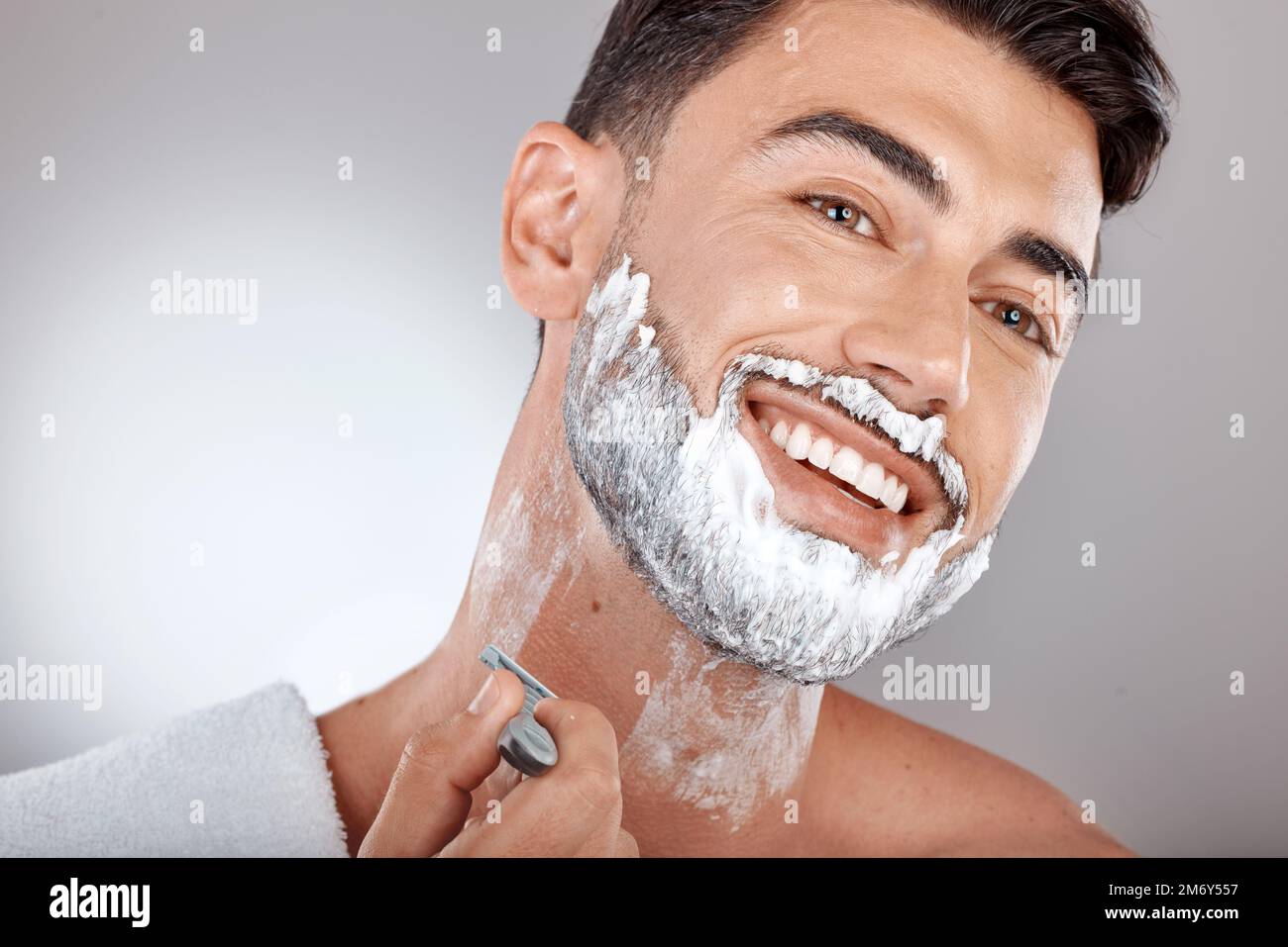 Grooming, foam and shaving with face of man with razor for beauty, hygiene and skincare with ...