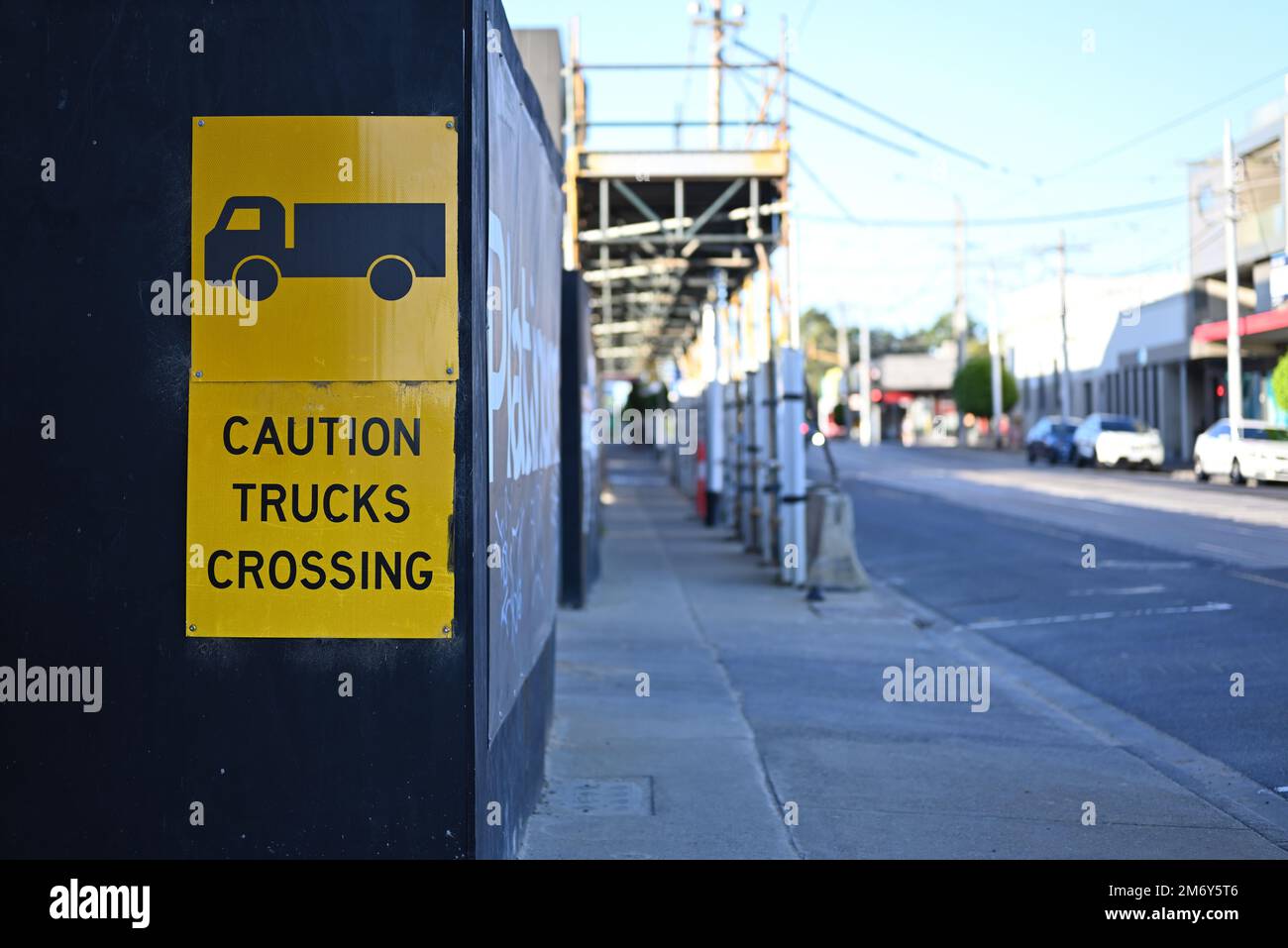 A yellow caution trucks crossing sign, with icon of a truck, on black ...