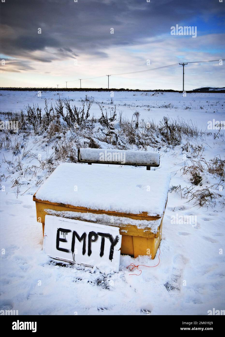 Empty yellow salt grit container in snow by the roadside Stock Photo ...